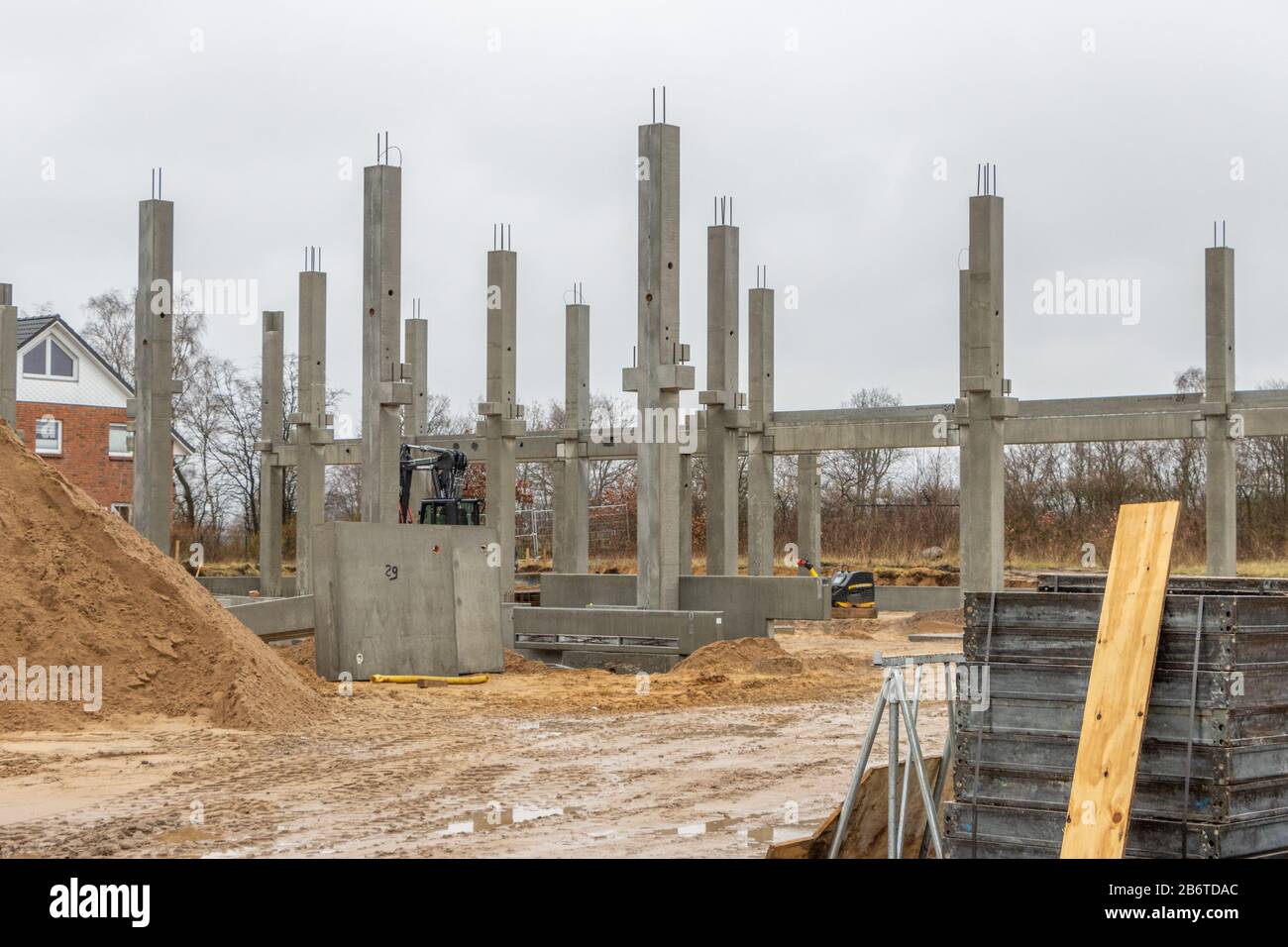 On a large construction site many concrete columns are placed with the ...