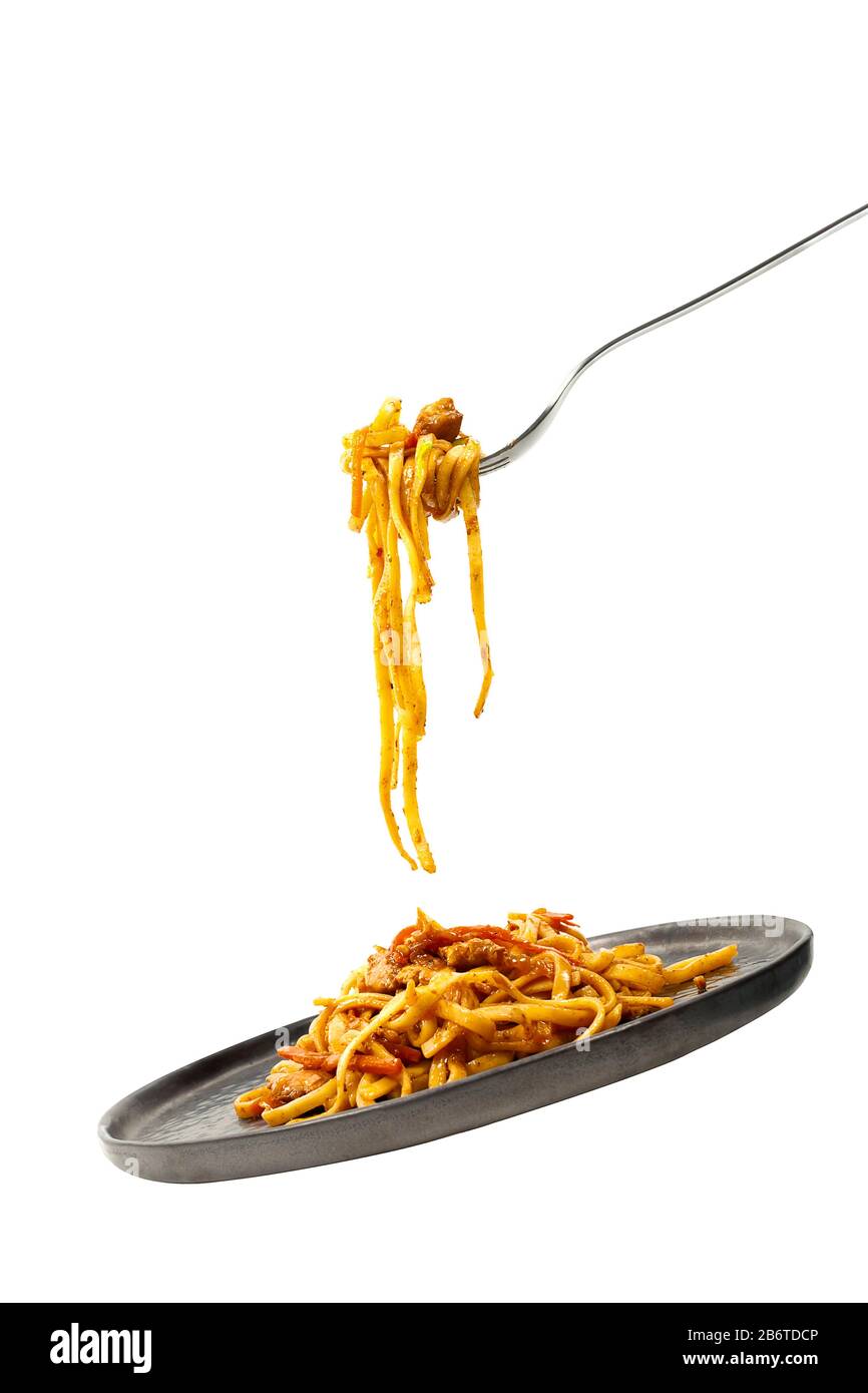 Pasta flying with fork and black plate. Isolated on white background ...