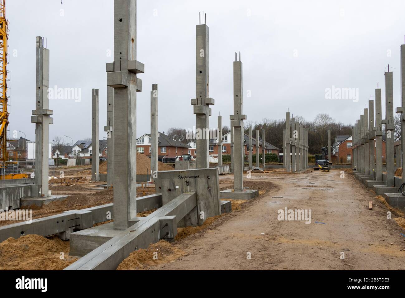 On a large construction site many concrete columns are placed with the ...