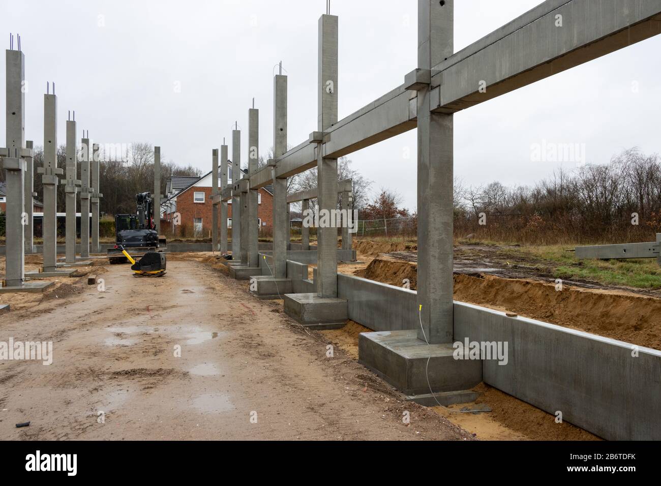 On a large construction site many concrete columns are placed with the ...