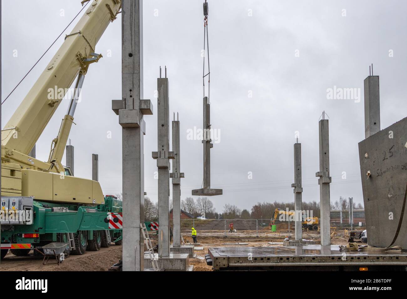 On a large construction site many concrete columns are placed with the ...