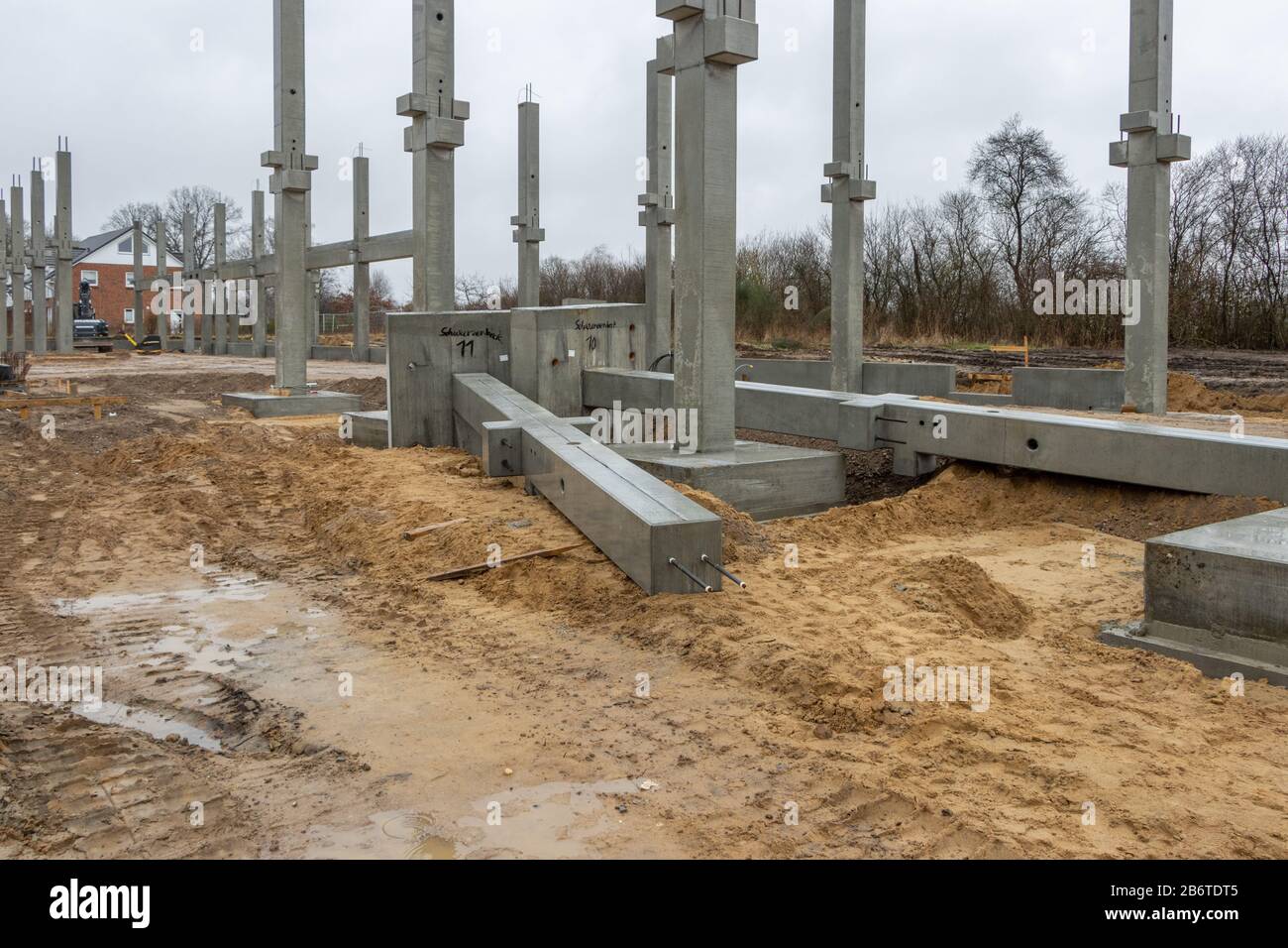 On a large construction site many concrete columns are placed with the ...