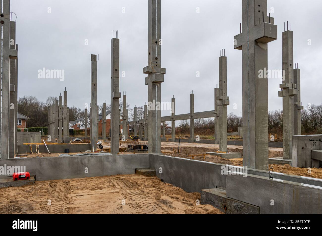 On a large construction site many concrete columns are placed with the ...