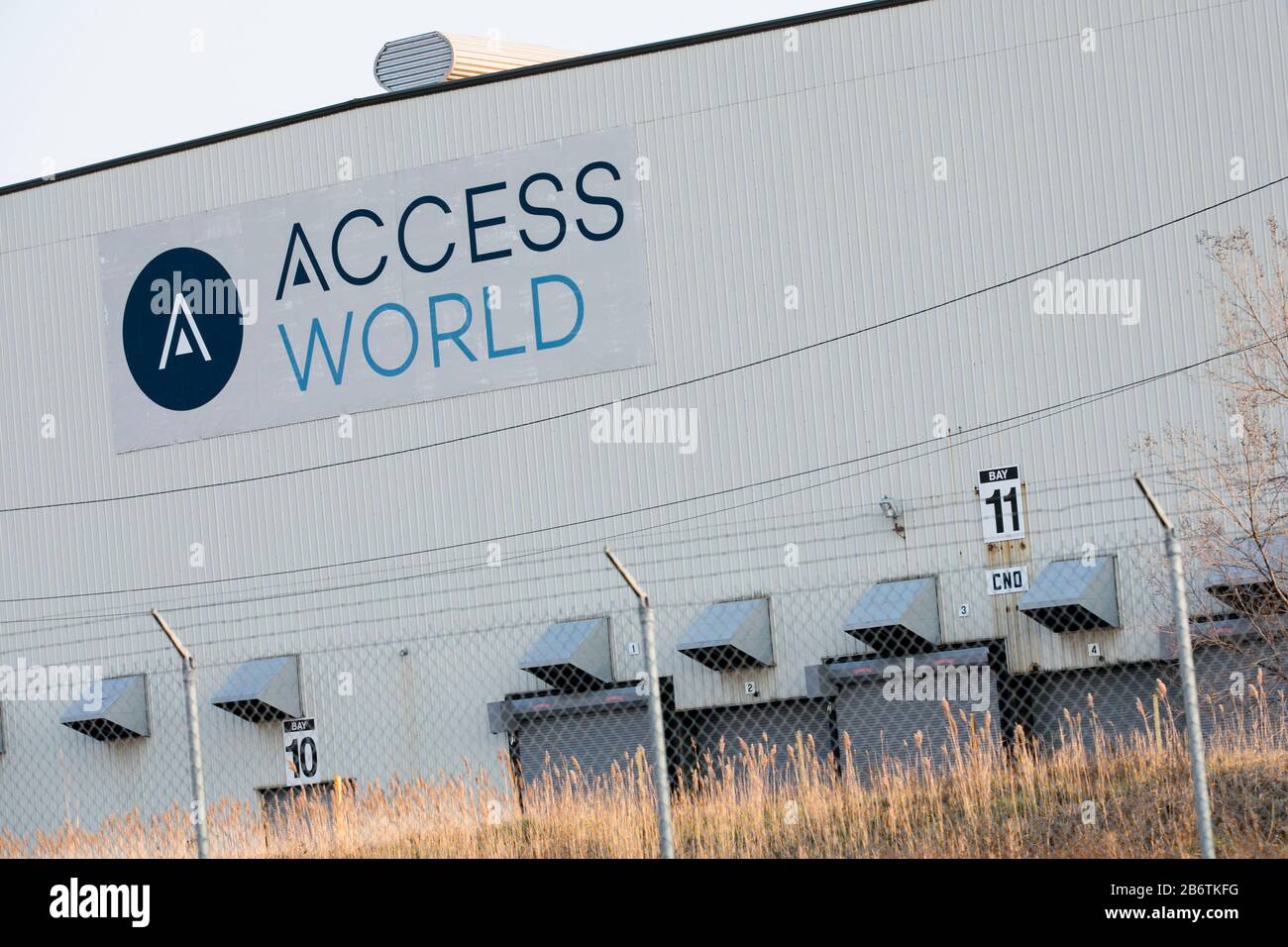 A logo sign outside of a facility occupied by Access World in Edgemere ...
