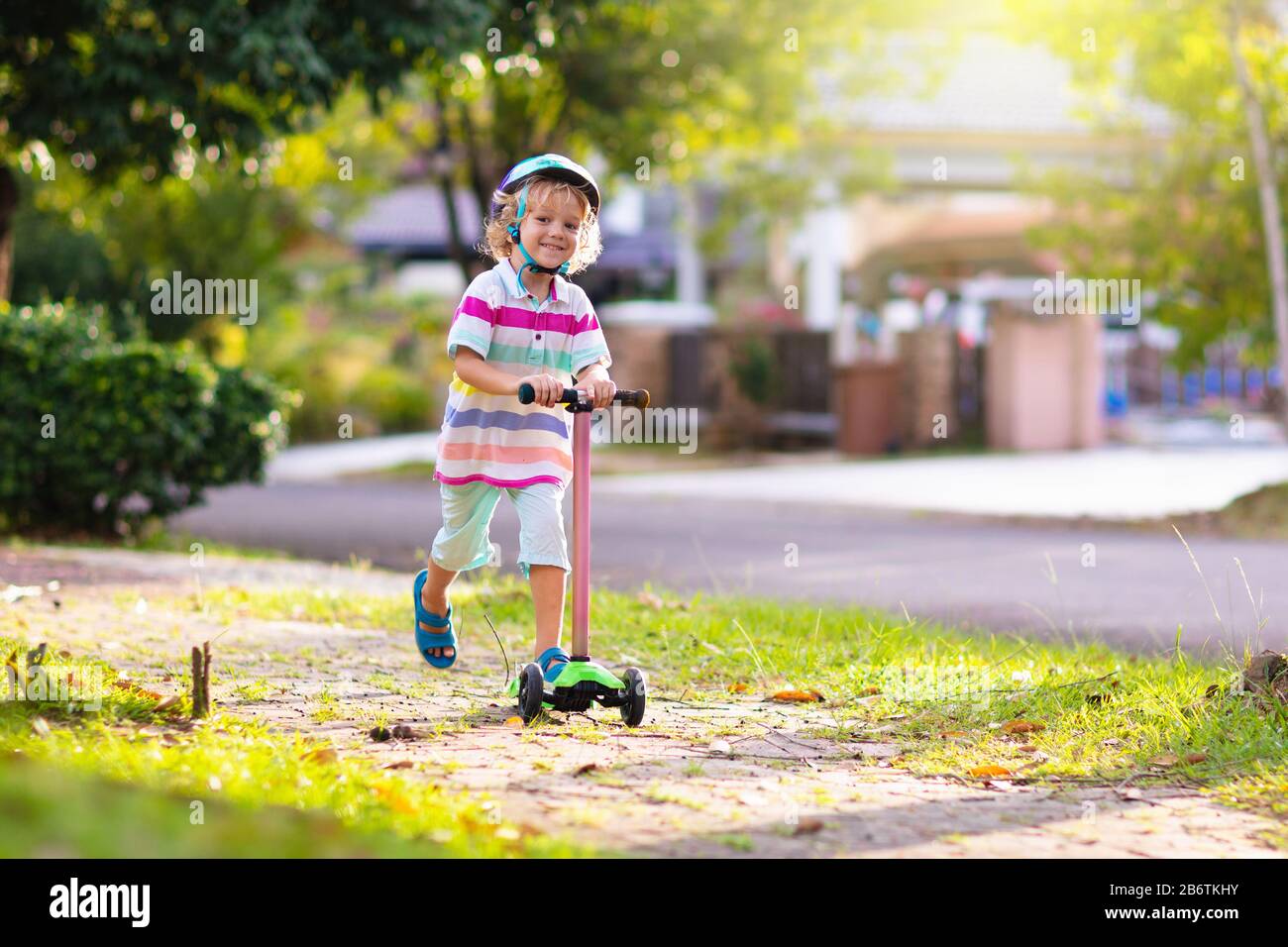 Little boy riding scooter. Kids ride kick board. Child playing on ...