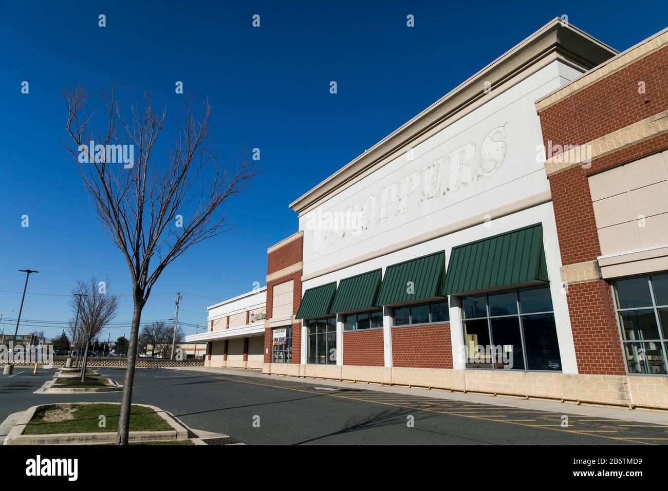 The faded outline of a logo sign outside of a closed and abandoned ...