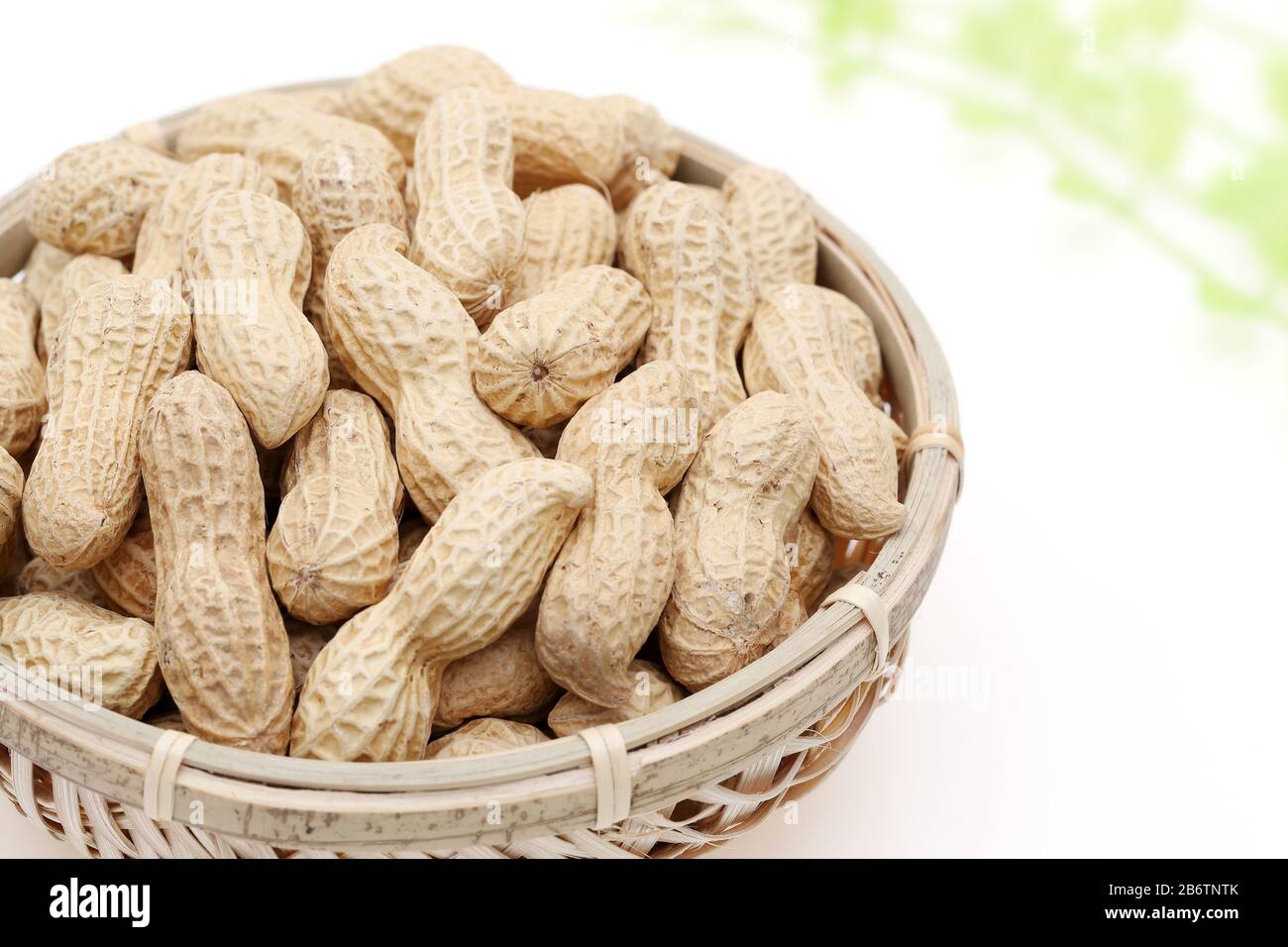 Organic peanuts in shell in a bamboo basket on white background Stock ...