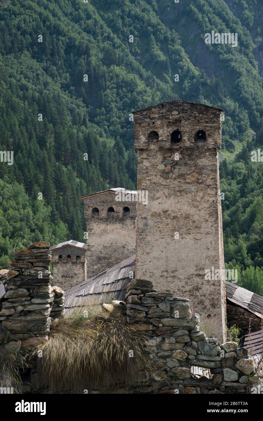 Traditional Svaneti stone towers against green mountain background ...