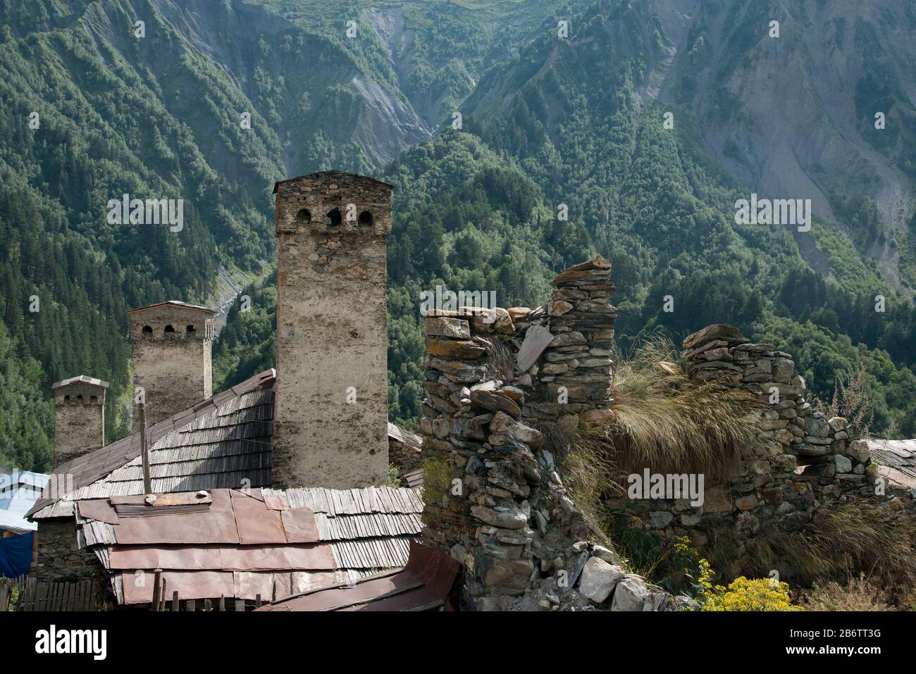 Poor people houses are nested near old stone towers. Covered with ...