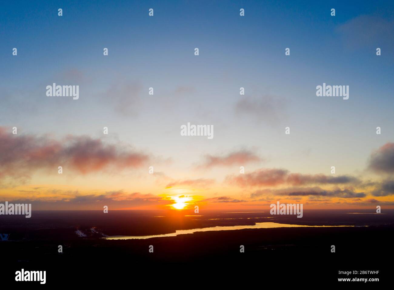 Aerial view sunset over the forest and lake. Top view. View from drone ...