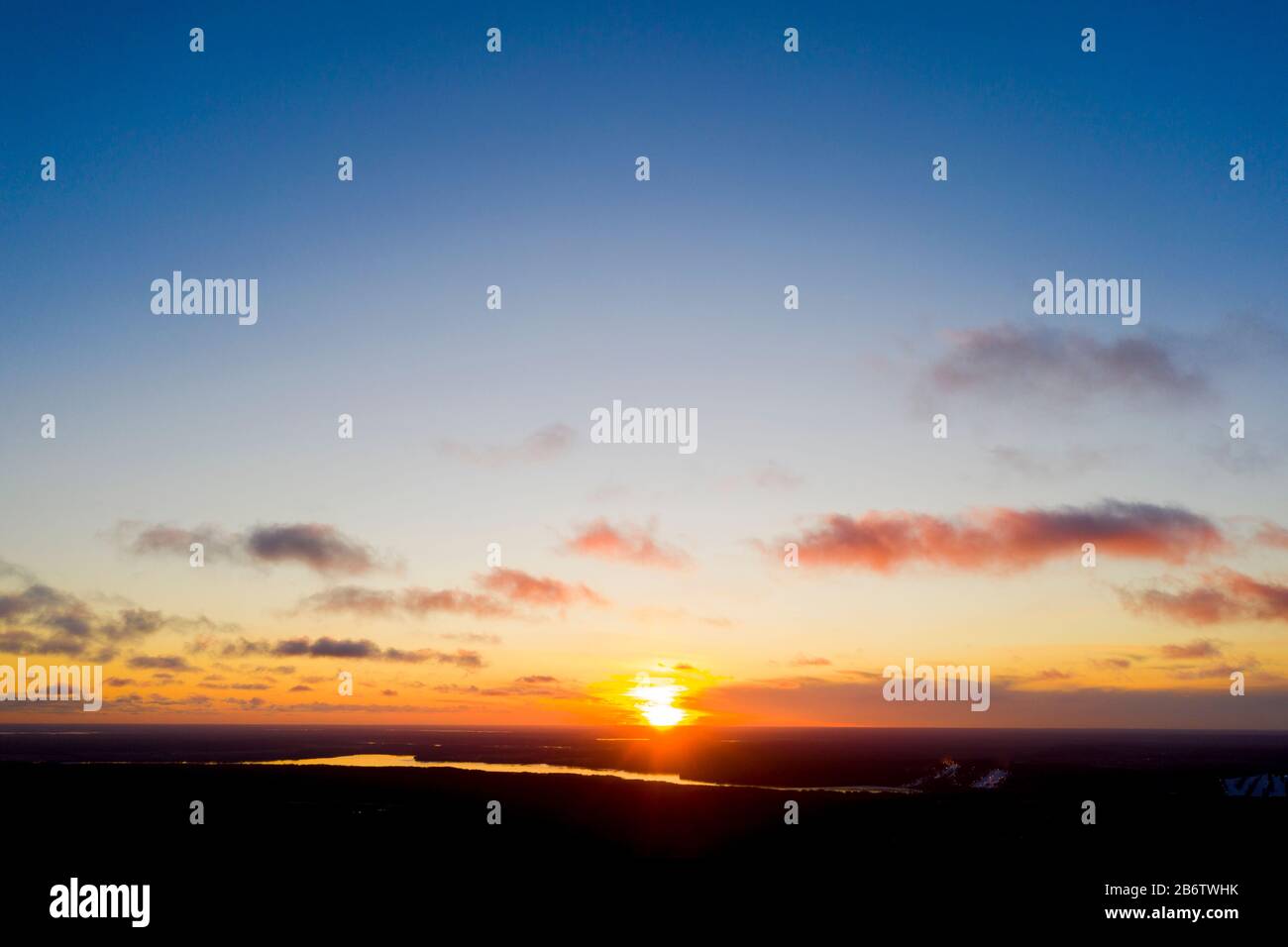 Aerial view sunset over the forest and lake. Top view. View from drone ...
