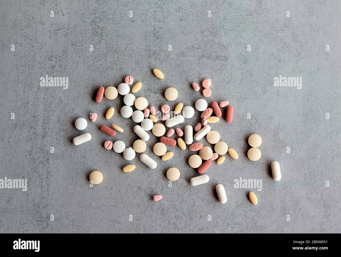 A heap of different colour and size pills on grey background Stock ...