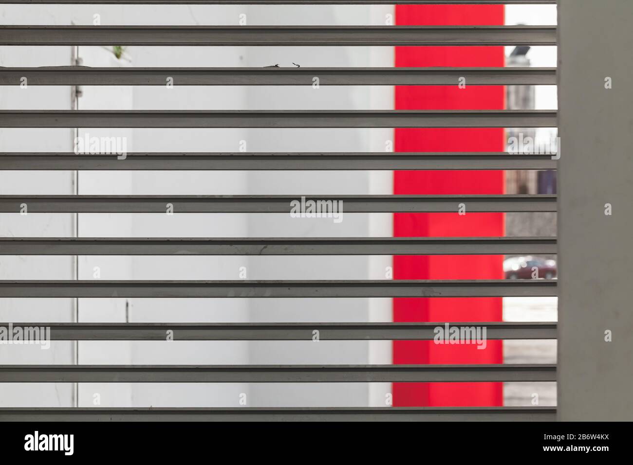 Metal protection window grill with red stripe behind it, abstract ...