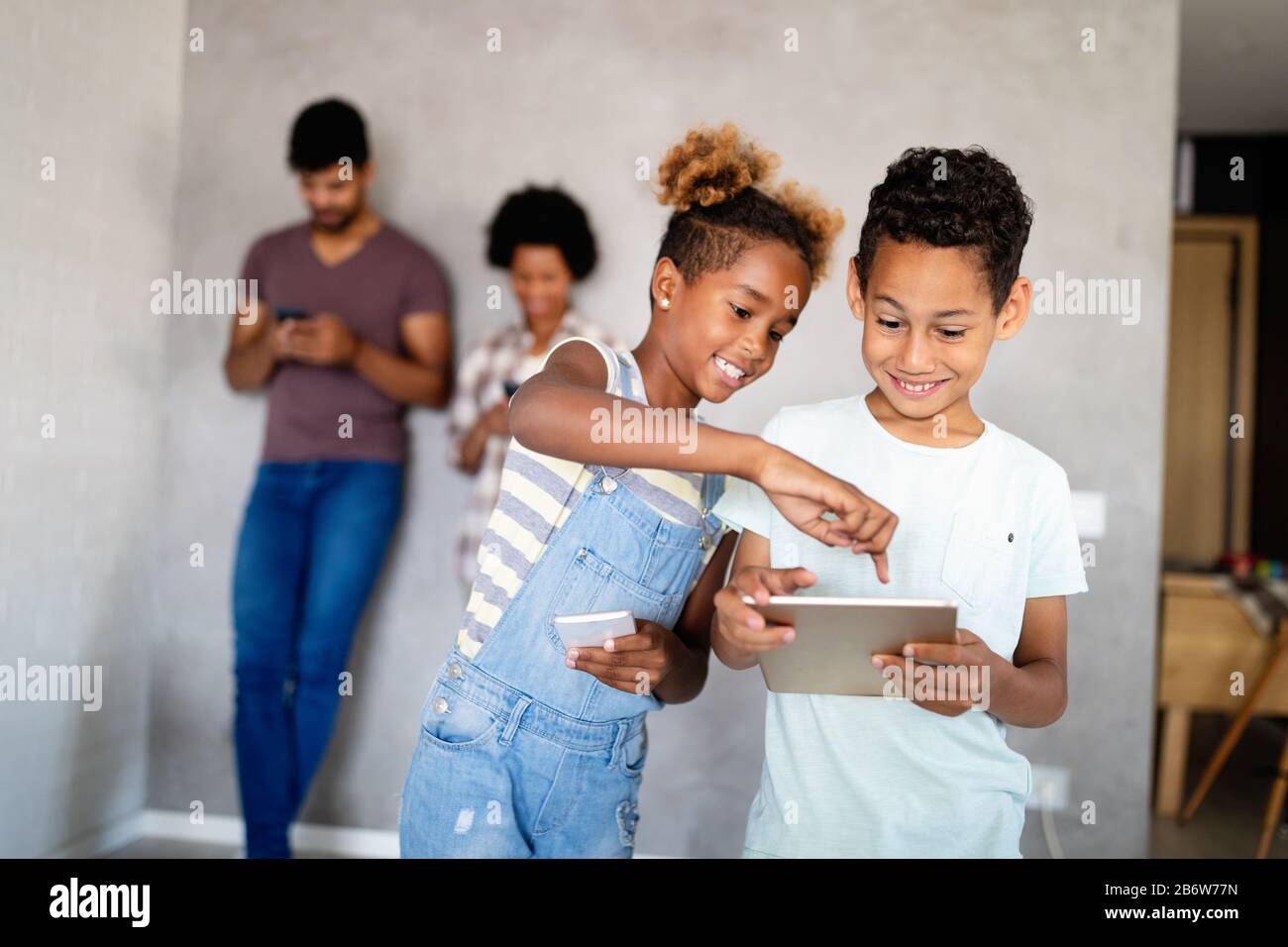 Happy african american family using technical devices, phone. tablet ...