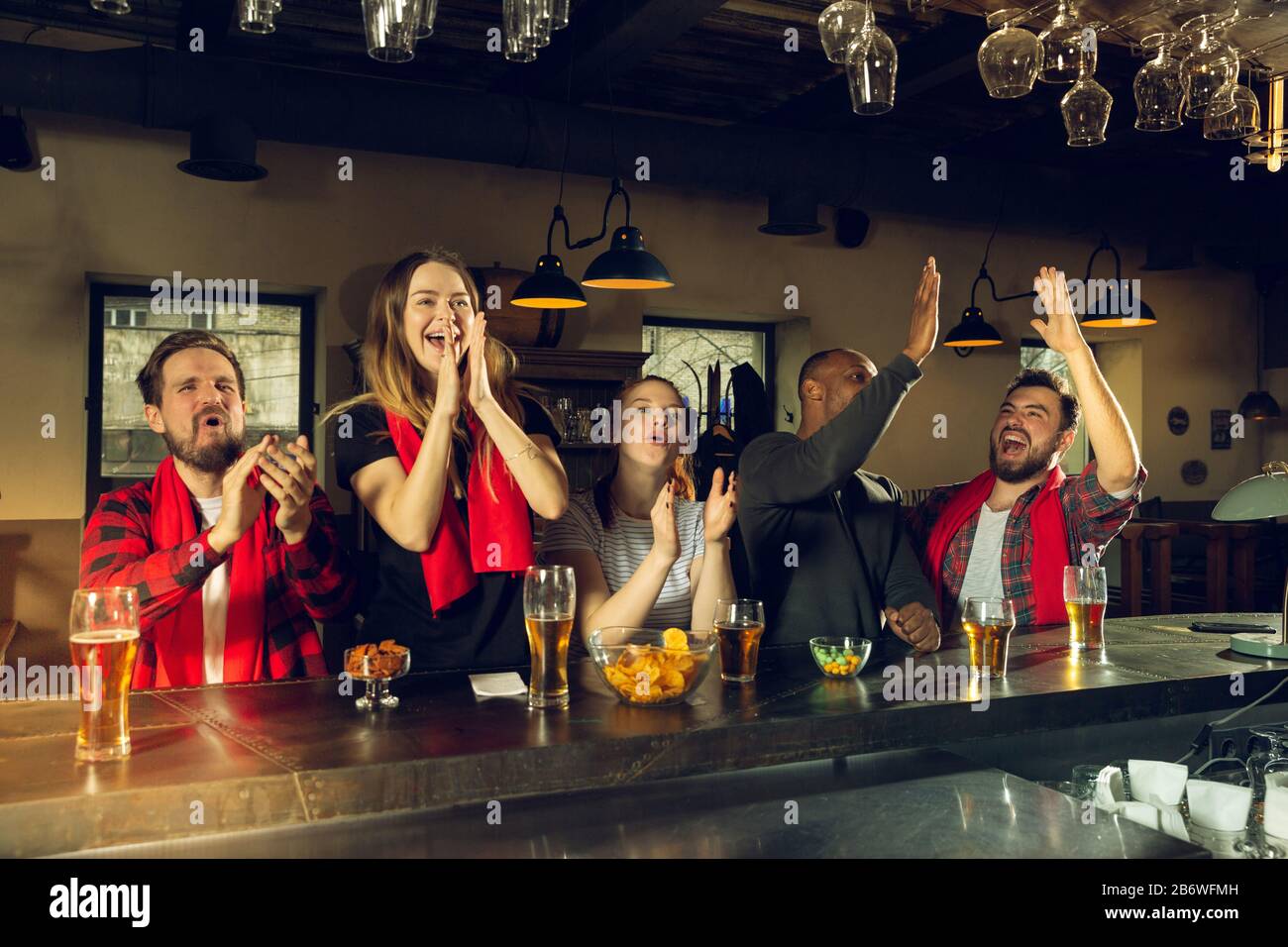 Sport fans cheering at bar, pub and drinking beer while championship ...