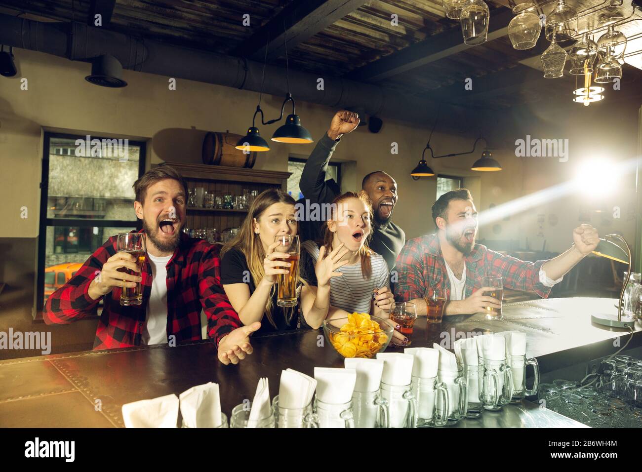 Sport fans cheering at bar, pub and drinking beer while championship ...