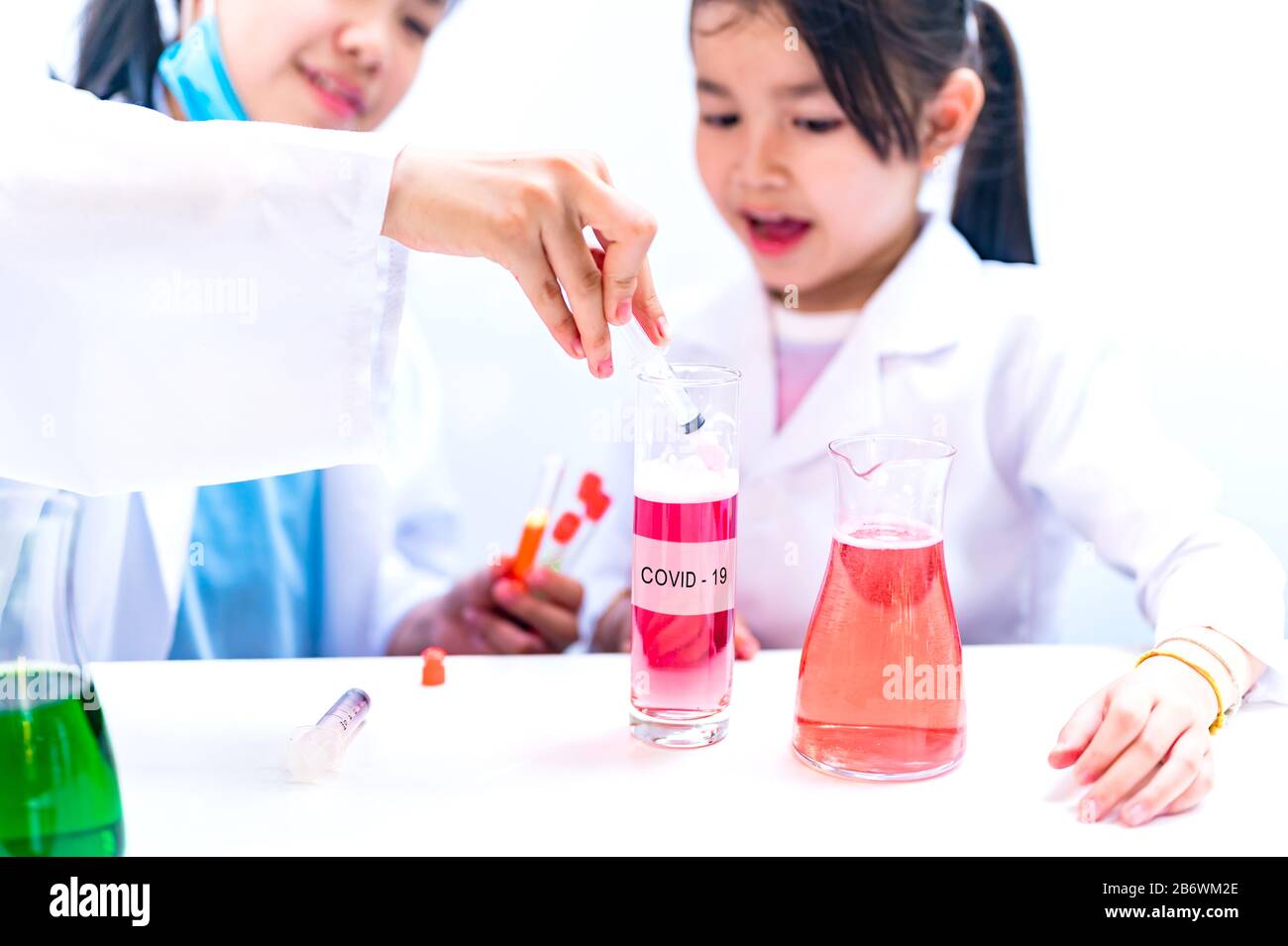 Asian young scientist with tube sample COVID-19 test. Kids doctor ...