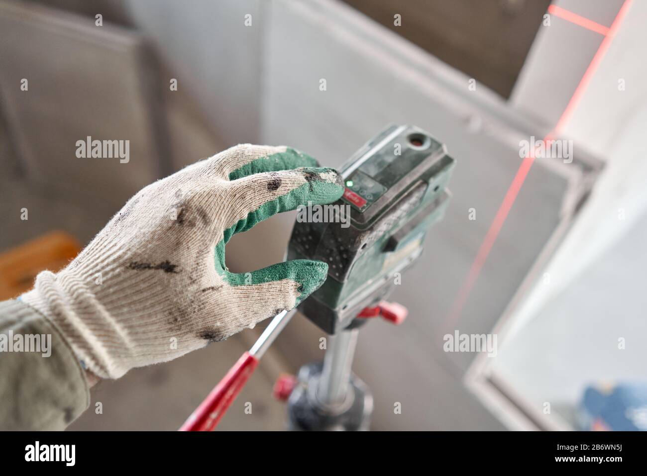The construction worker Measures horizon level with a laser level ...