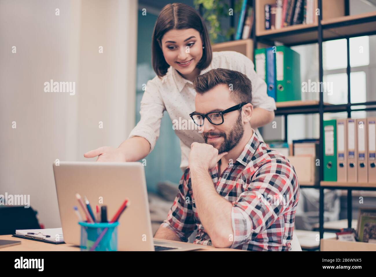 Young female manager helping her colleague with task Stock Photo - Alamy