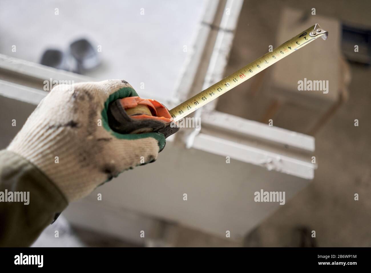 The construction worker measures with a tape measure Gypsum plate ...