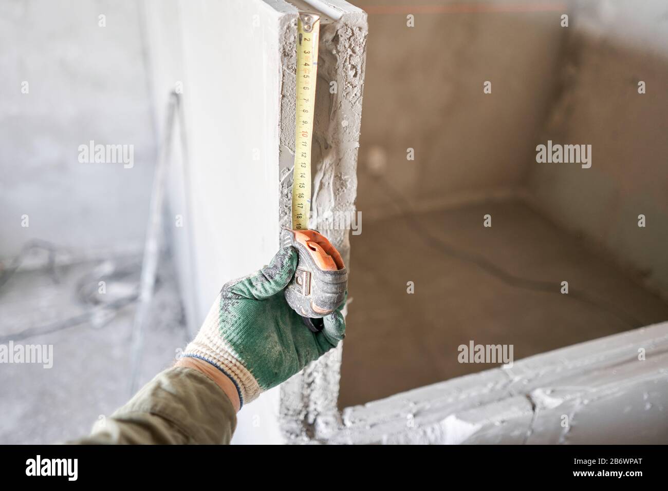 The construction worker measures with a tape measure Gypsum plate ...