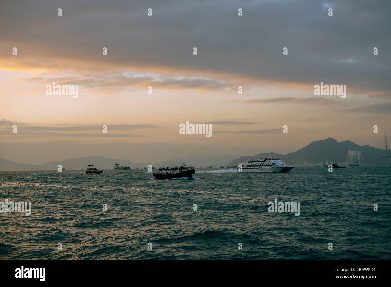 Boats sailing in Hong Kong river with island in the background Stock ...
