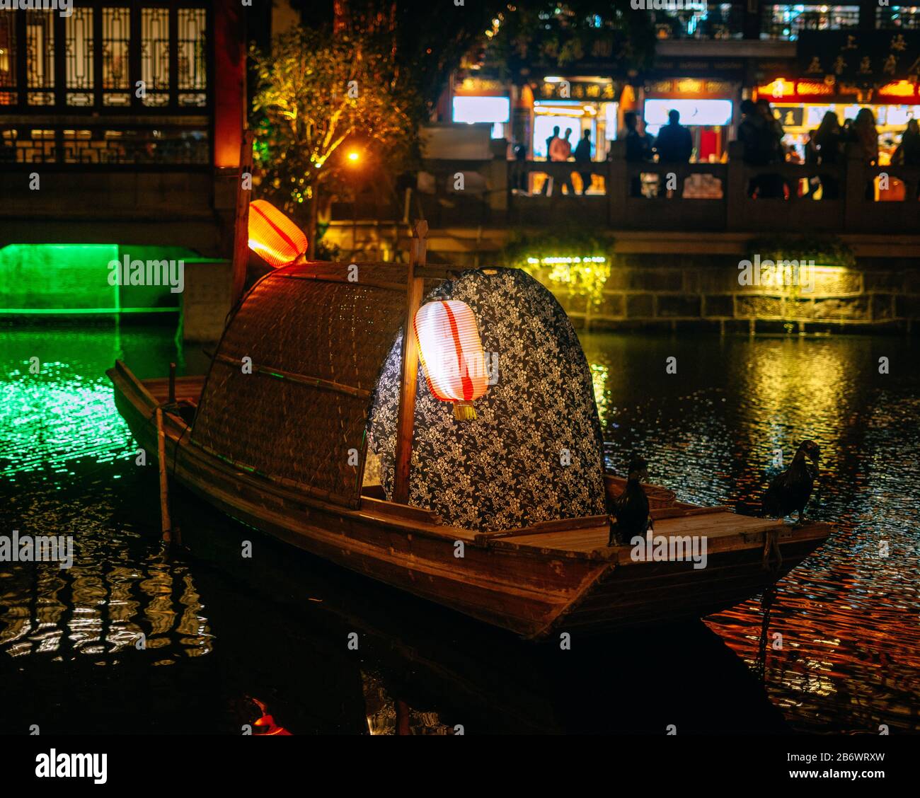 Traditional chinese boat with paper lanterns and lights in a lake at ...