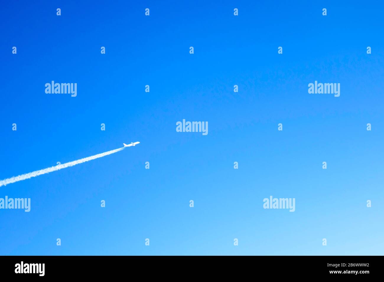 Airplane in the blue sky far from here. Travel concept Stock Photo - Alamy