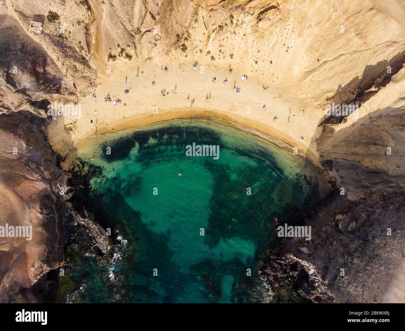 Aerial shot of village in Famara, Canary islands with ocean waves and ...