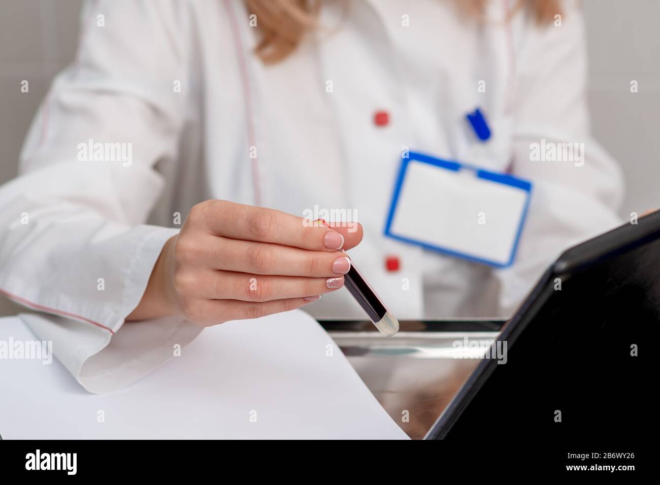 Nurse writes diagnosis with blood sample tubes in gadget tablet at ...