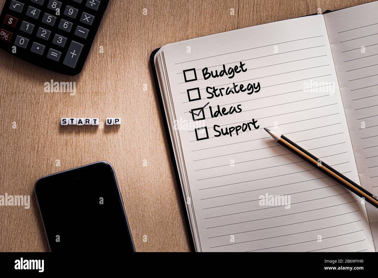 Start up in white square letters with list handwritten budget strategy ...