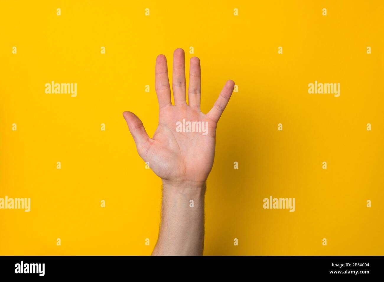 man hand up over a yellow background with copyspace for advert banner ...