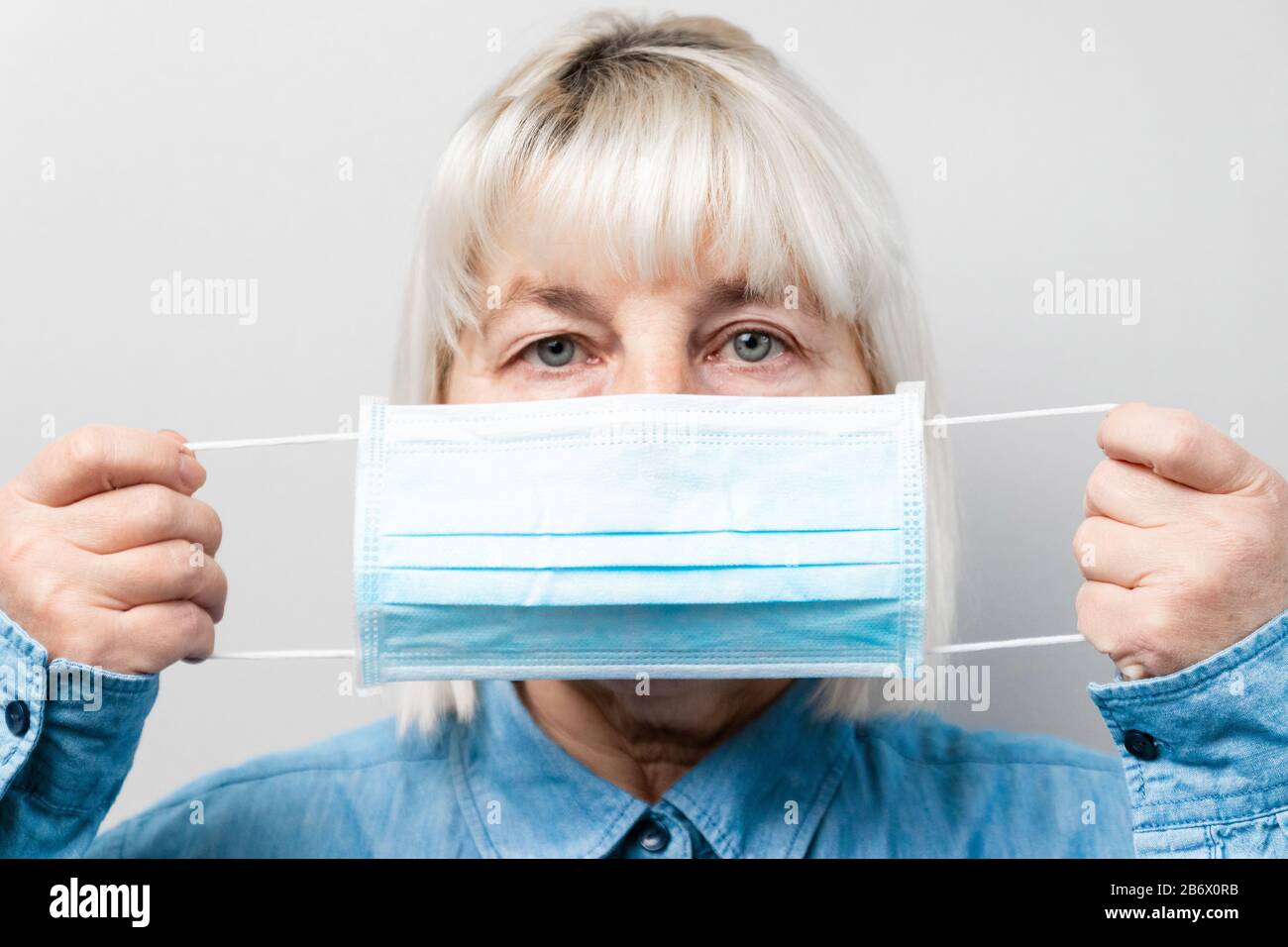 Adult woman shows how to wear a medical mask. Protection against ...