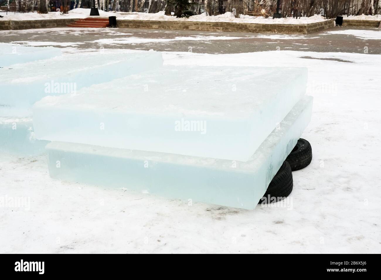 Ice blocks lie on rubber tires. Black tires as a stand. Ice for ...