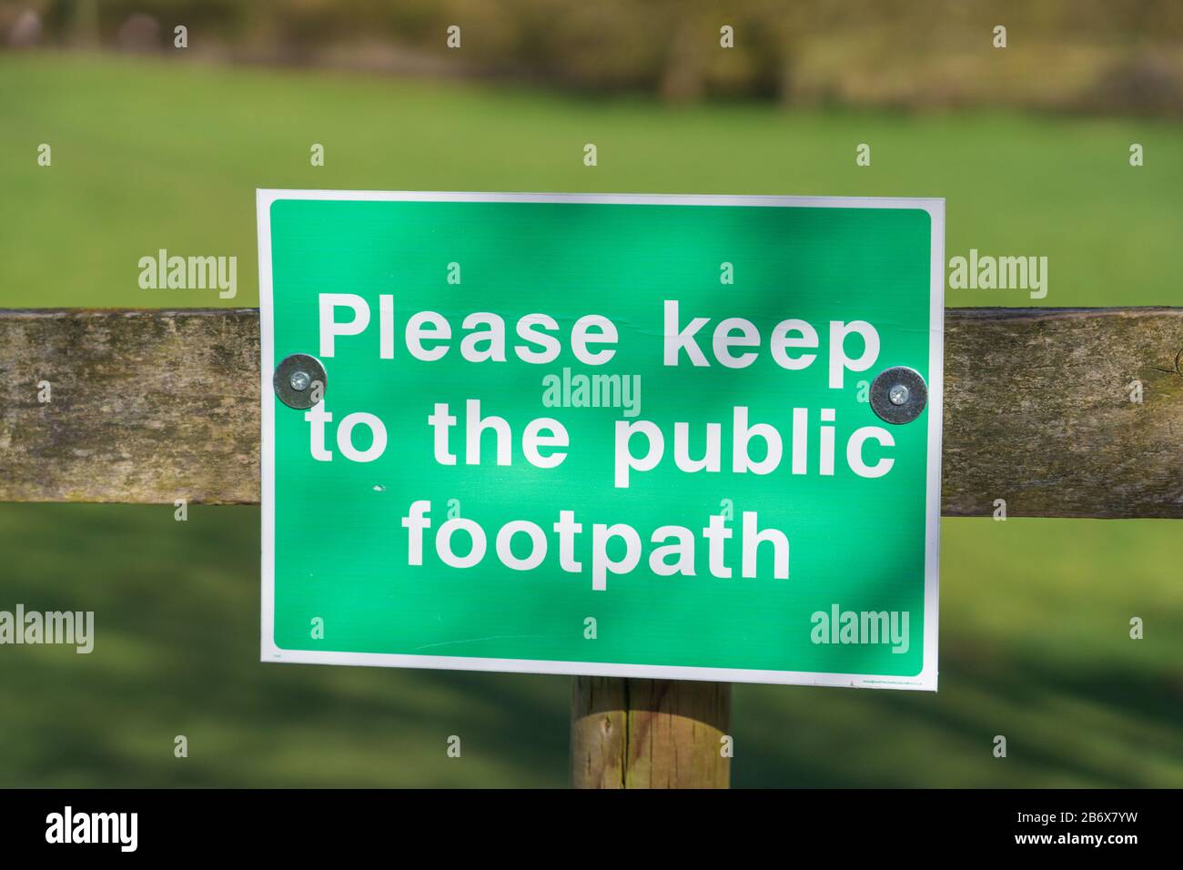 Country sign on gate instructing people to keep to the public footpath ...