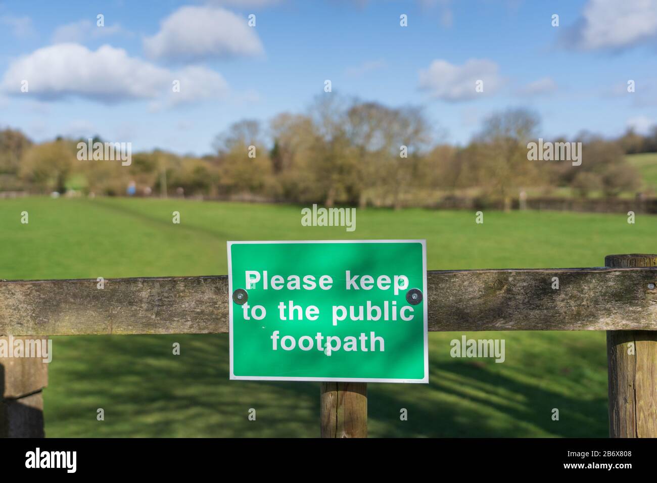 Country sign on gate instructing people to keep to the public footpath ...