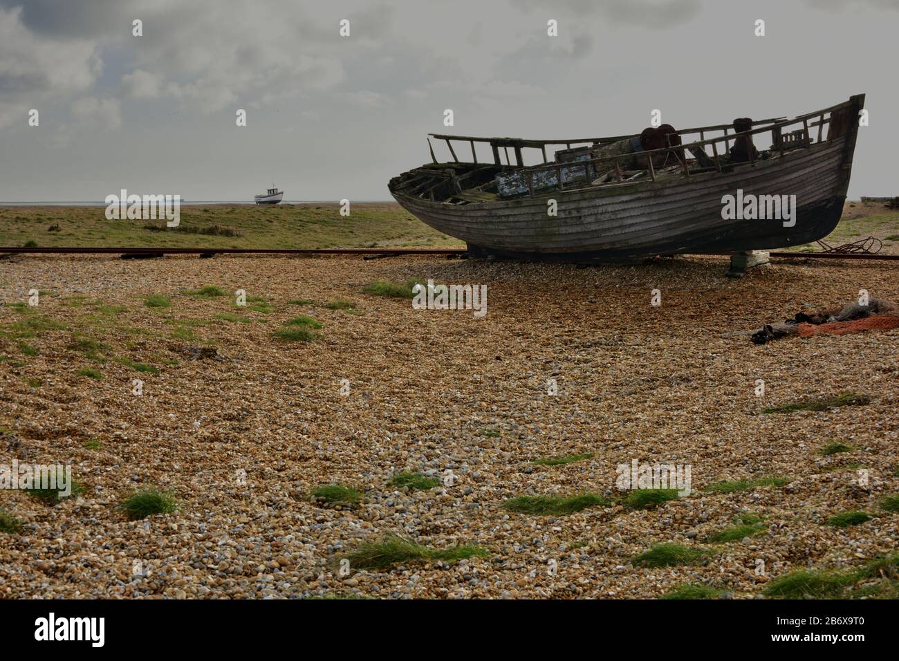 A derelict fishing boat rotting on the shingle at Dungeness Stock Photo ...