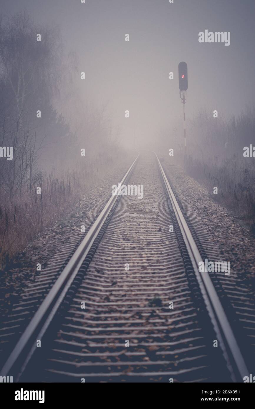 Perspective of railway track disappearing in mist in foggy morning ...