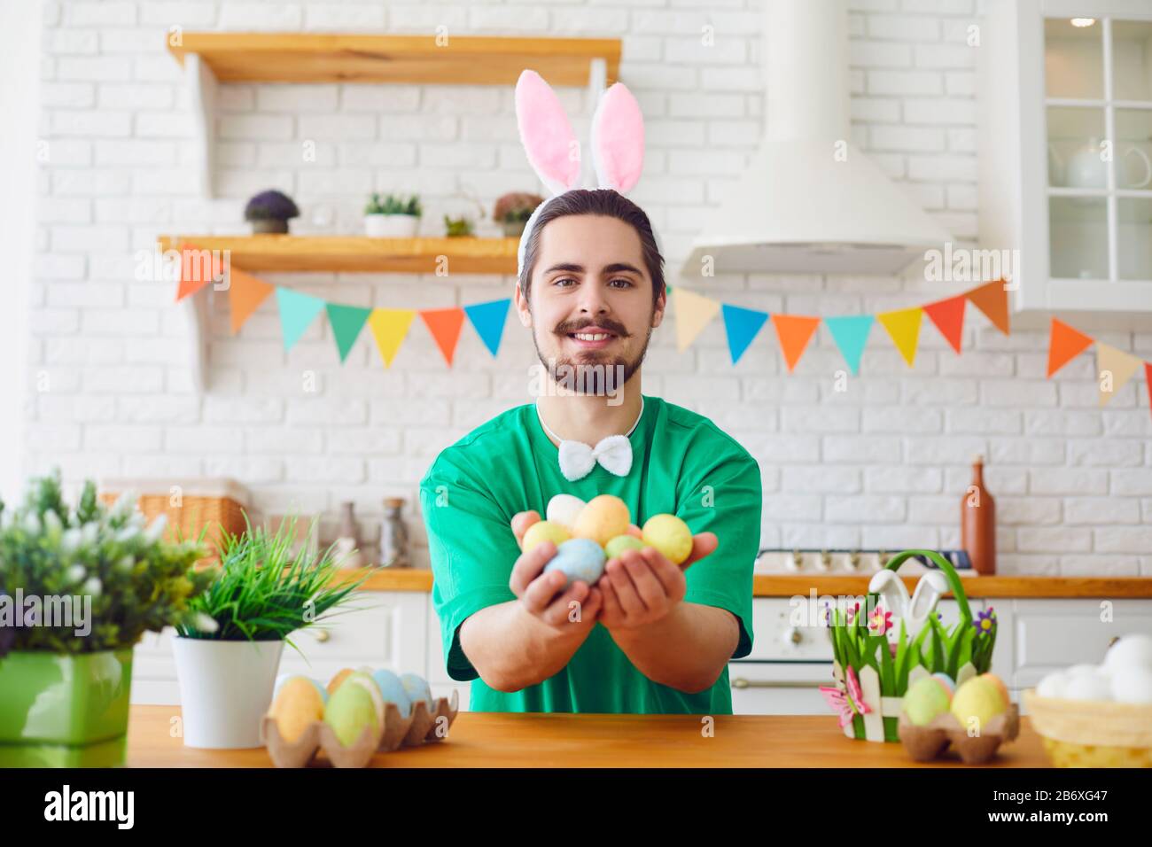 Happy Easter. A funny bearded man holds eggs in his hands and sits in ...