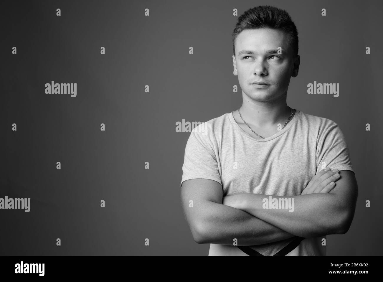 Portrait of young handsome man against gray background Stock Photo - Alamy