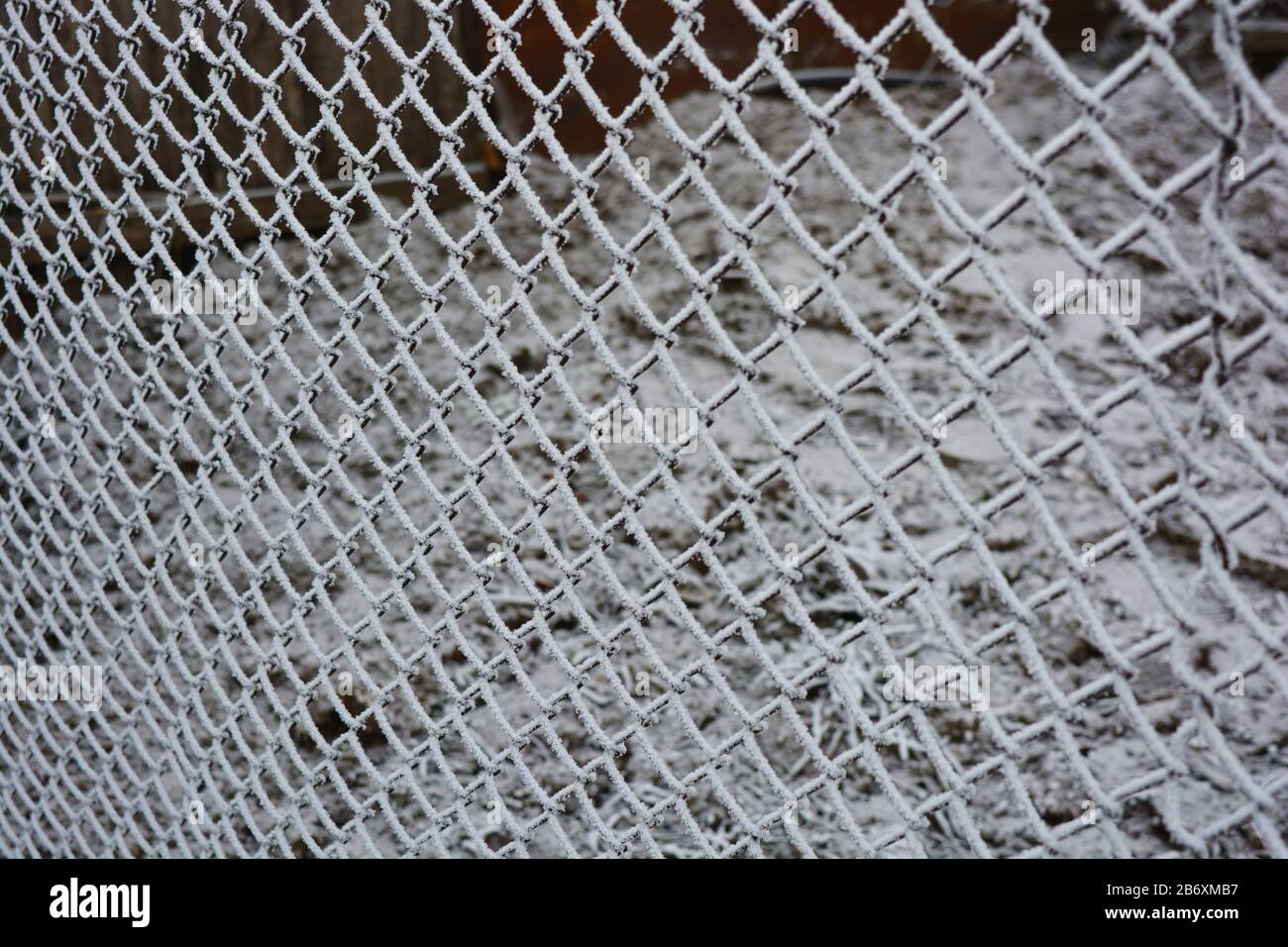 Metallic old rusty netting net decorated with white snow, bright ...
