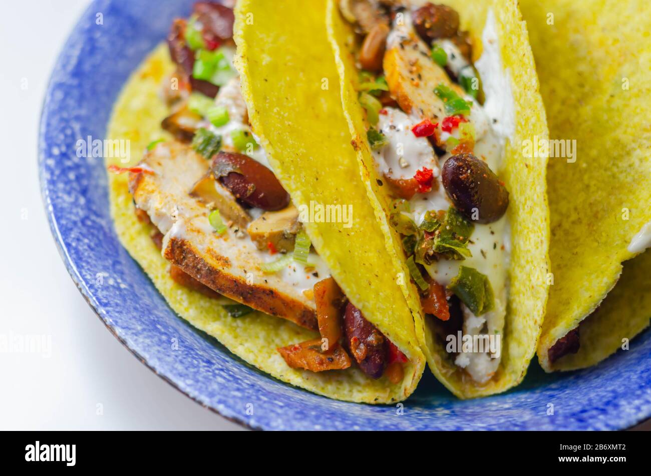 Mexican tacos shells with chicken and red kidney beans, onion, red and ...