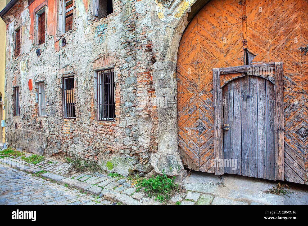 old house with big wooden gate and broken wall Stock Photo - Alamy