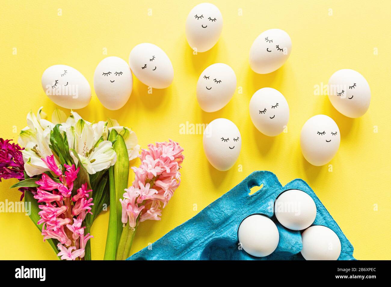 Creative easter eggs with cute face and sleepy eyes on pastel yellow ...