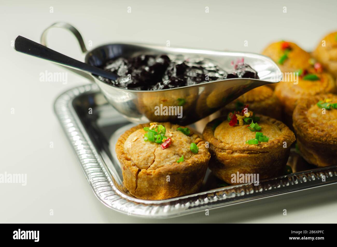 Traditional English pork pies with cranberry sauce on a silver tray ...