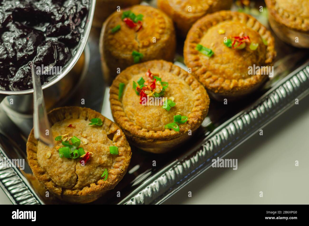 Traditional English pork pies with cranberry sauce on a silver tray ...