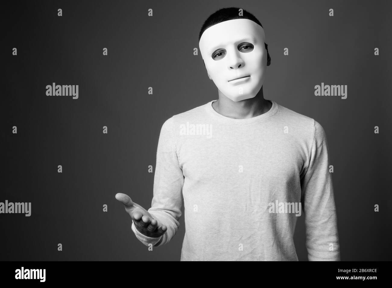 Portrait of young man with white mask against gray background Stock ...
