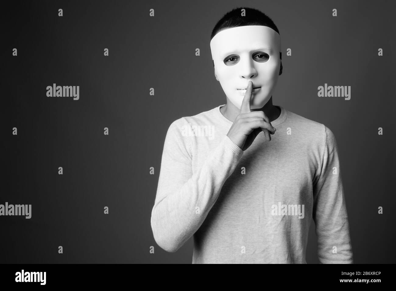 Portrait of young man with white mask against gray background Stock ...