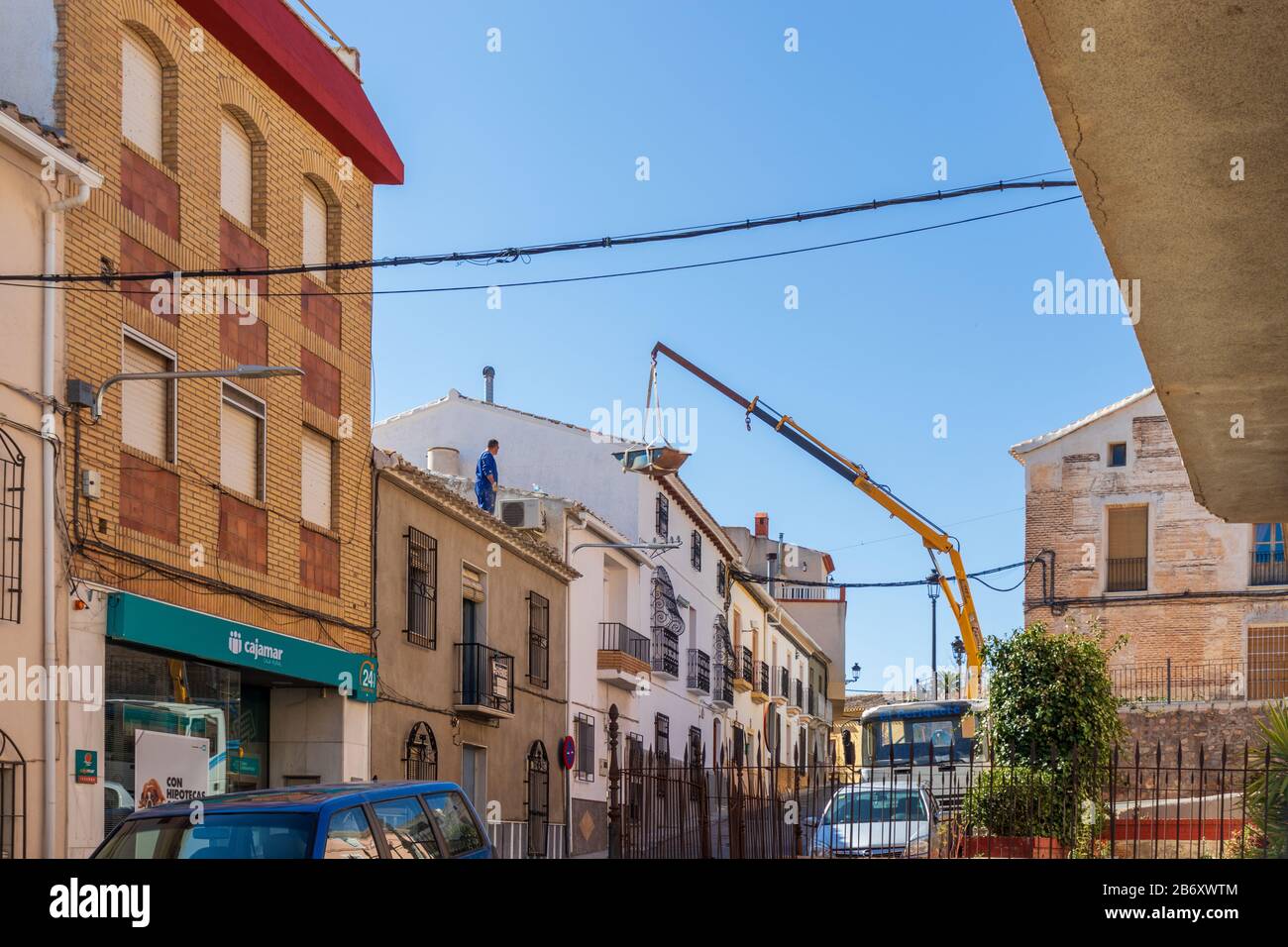 Workmen Using a Crane to Deliver Building Supplies on to a Rooftop in ...