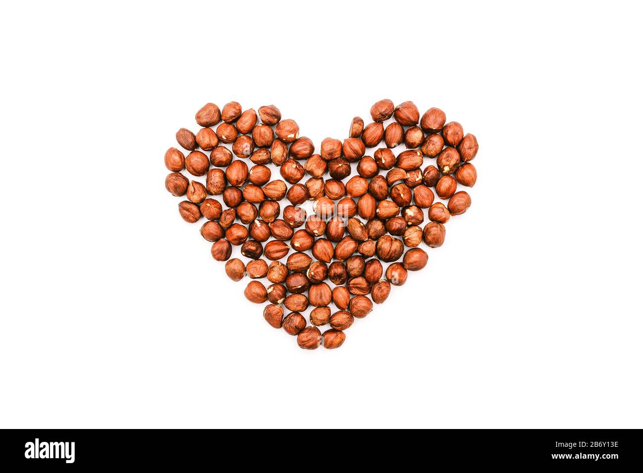 Heart shape made of nuts. Brown hazelnut kernels on a white background ...